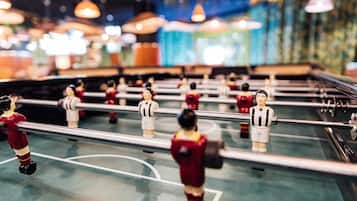 Uma mesa de futebol de mesa com jogadores de uniformes vermelhos e brancos.