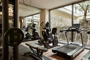 Uma academia moderna com esteiras, bicicletas ergométricas e aparelhos de musculação.