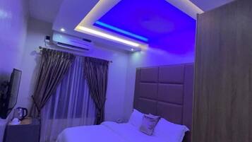 Um quarto moderno com cama, ar condicionado e luminária no teto.