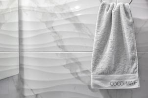Uma toalha pendurada em um suporte, com o texto "COCO-MAT" visível.