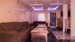Uma sala de estar moderna com sofá, mesa de centro e frigorífico.