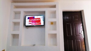 Televisão fixada na parede exibindo a programação de um canal esportivo.