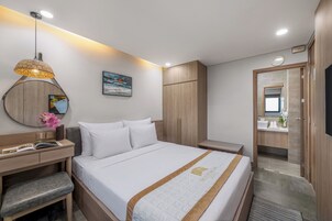 Quarto de hotel moderno com cama, mesa de cabeceira, luminária, obra de arte e guarda-roupa.