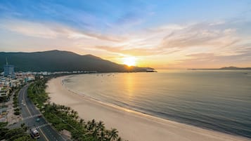 Uma estrada costeira com uma praia e uma montanha ao fundo.
