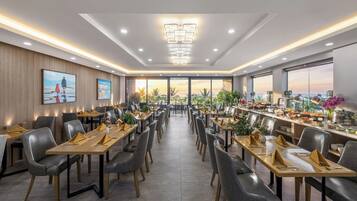 Uma área de refeições moderna com mesas longas, cadeiras e um buffet.
