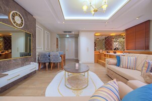 Uma sala de estar moderna com um sofá, uma mesa de centro redonda e um espaço de refeições com cadeiras e uma mesa.
