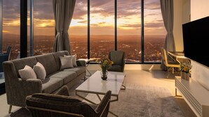 Uma sala de estar moderna com vista para a cidade, um sofá, uma mesa de centro e uma televisão.
