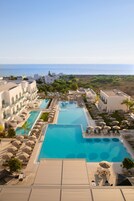 Resort com várias piscinas, espreguiçadeiras e guarda-sóis.