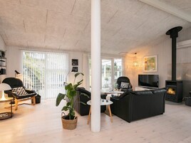 Uma sala de estar moderna com lareira, assentos confortáveis e uma grande janela.