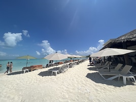 Na praia, praia de areia branca, guarda-sóis de praia, 2 bares na praia