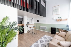 Um apartamento moderno com cozinha, sala de jantar e sala de estar com sofá e mesa de centro.