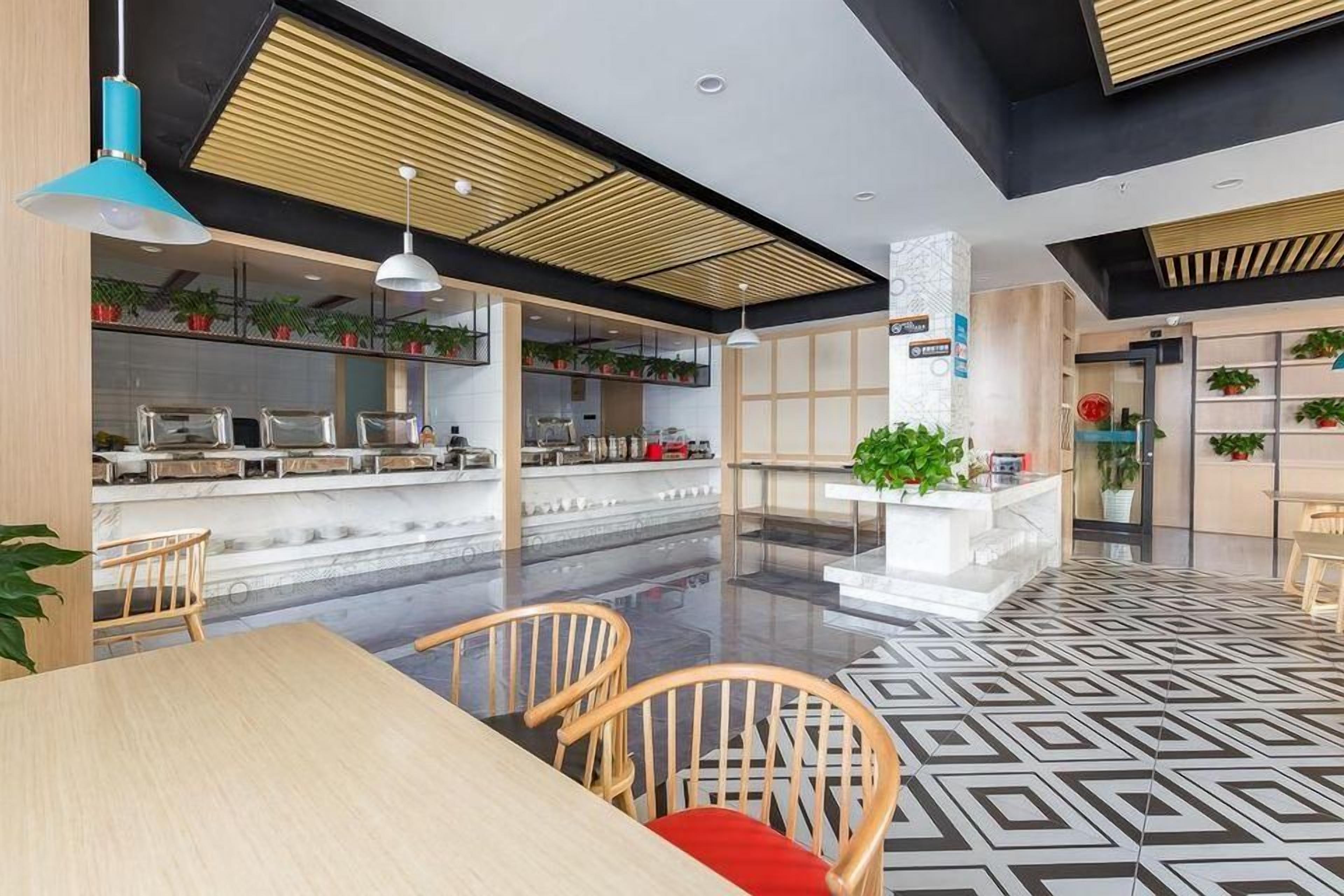 Cozinha moderna com ilha central, cadeiras de madeira e mesa de jantar.