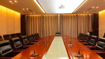 Sala de conferência com uma mesa comprida, várias cadeiras e um púlpito.