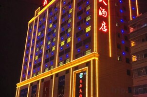 Um hotel com vários andares, sinalização iluminada e janelas.