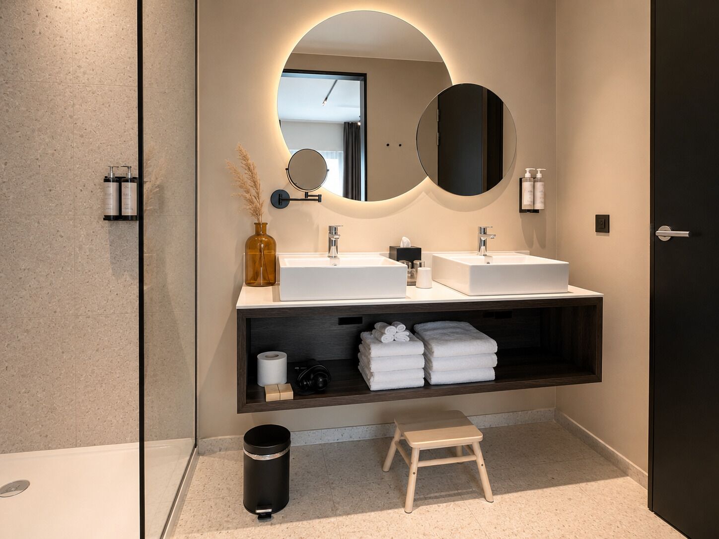 Uma casa de banho moderna com duas pias, um espelho e uma prateleira com toalhas.