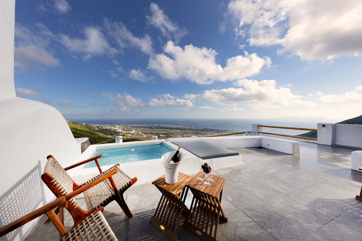Terraço no telhado com piscina, espreguiçadeiras e uma mesa com uma garrafa de champanhe.