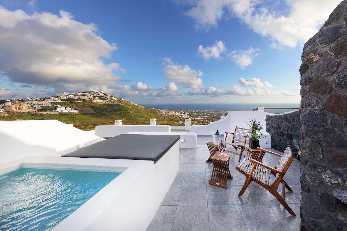 Terraço no telhado com piscina, área de estar e vista para uma cidade costeira.