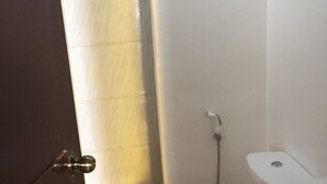 Um banheiro pequeno com vaso sanitário, chuveiro e pia.