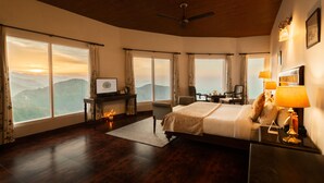 Quarto espaçoso com uma cama grande, uma escrivaninha e uma cadeira. Possui janelas amplas com vista para as montanhas.