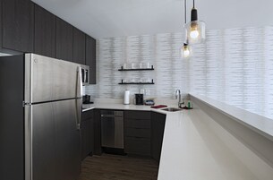 Um frigorífico, um micro-ondas, uma cafeteira/bule 