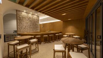 Cozinha moderna com parede de pedra, teto de madeira e área de bar com banquetas.