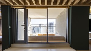 Apartamento moderno com porta de vidro deslizante que dá para uma varanda com vista para a cidade.