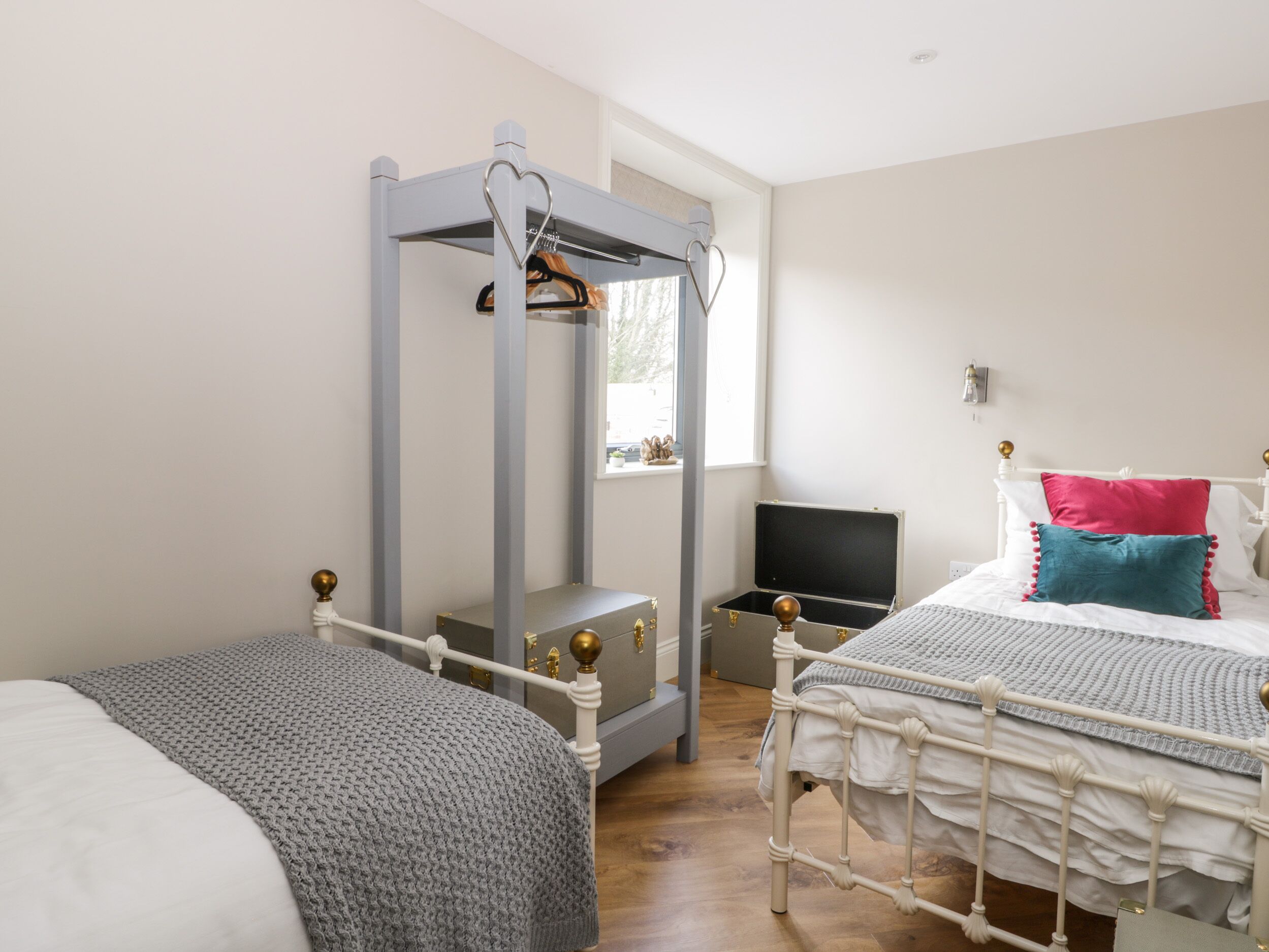 Quarto com cama, guarda-roupa, escrivaninha e janela.