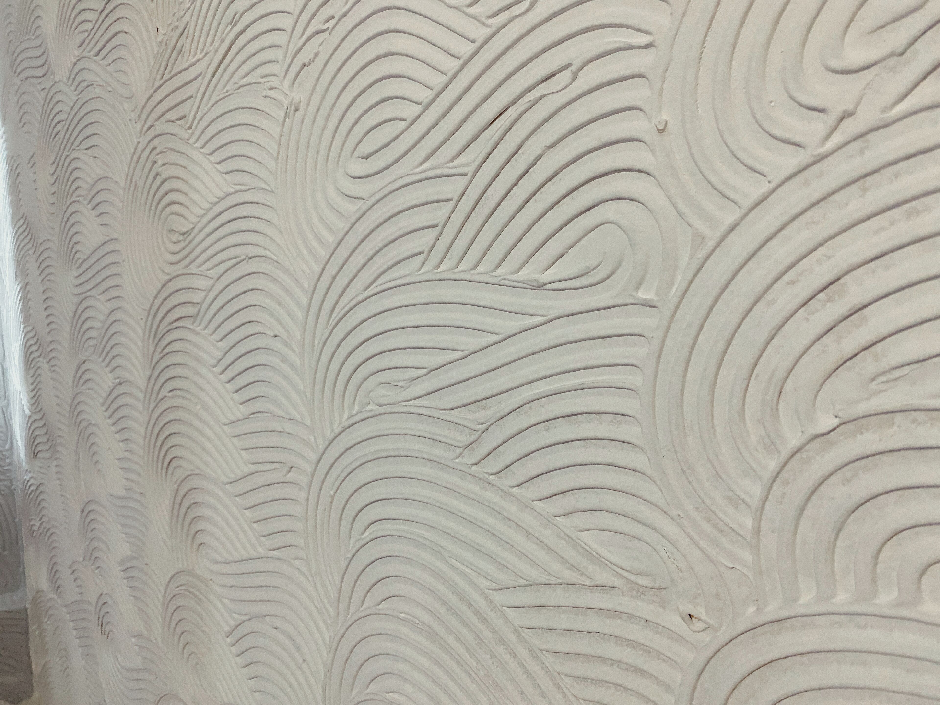 Parede texturizada com um padrão que lembra folhas.