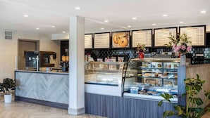 Um café moderno com balcão, cardápios e vitrine.