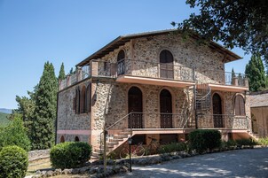Um edifício de pedra com varanda e escadas.