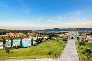 Um resort com piscina, um caminho pavimentado e vista para a paisagem ao redor.