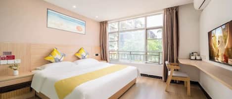 Quarto de hotel com uma cama grande, uma escrivaninha e uma janela com cortinas.