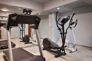 Uma academia com esteiras, elípticos e bicicletas ergométricas.
