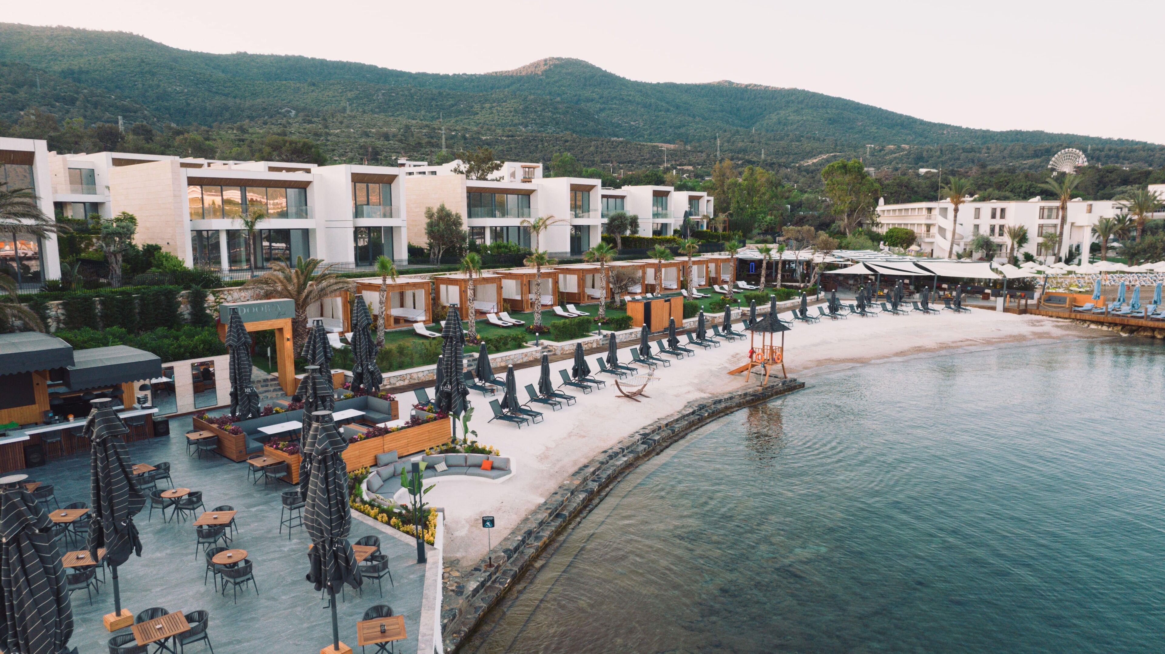 Um resort com vários edifícios, áreas de estar ao ar livre e uma praia.
