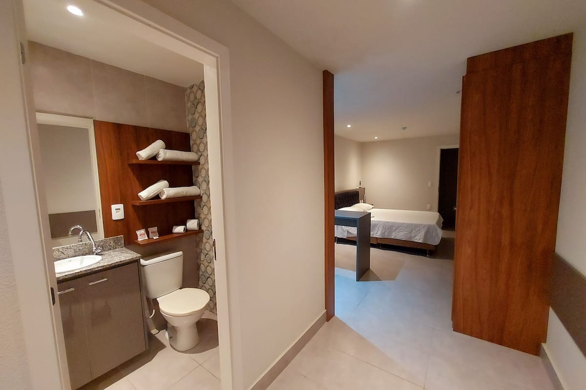 Uma casa de banho moderna com lavatório, sanita e espaço para toalhas.