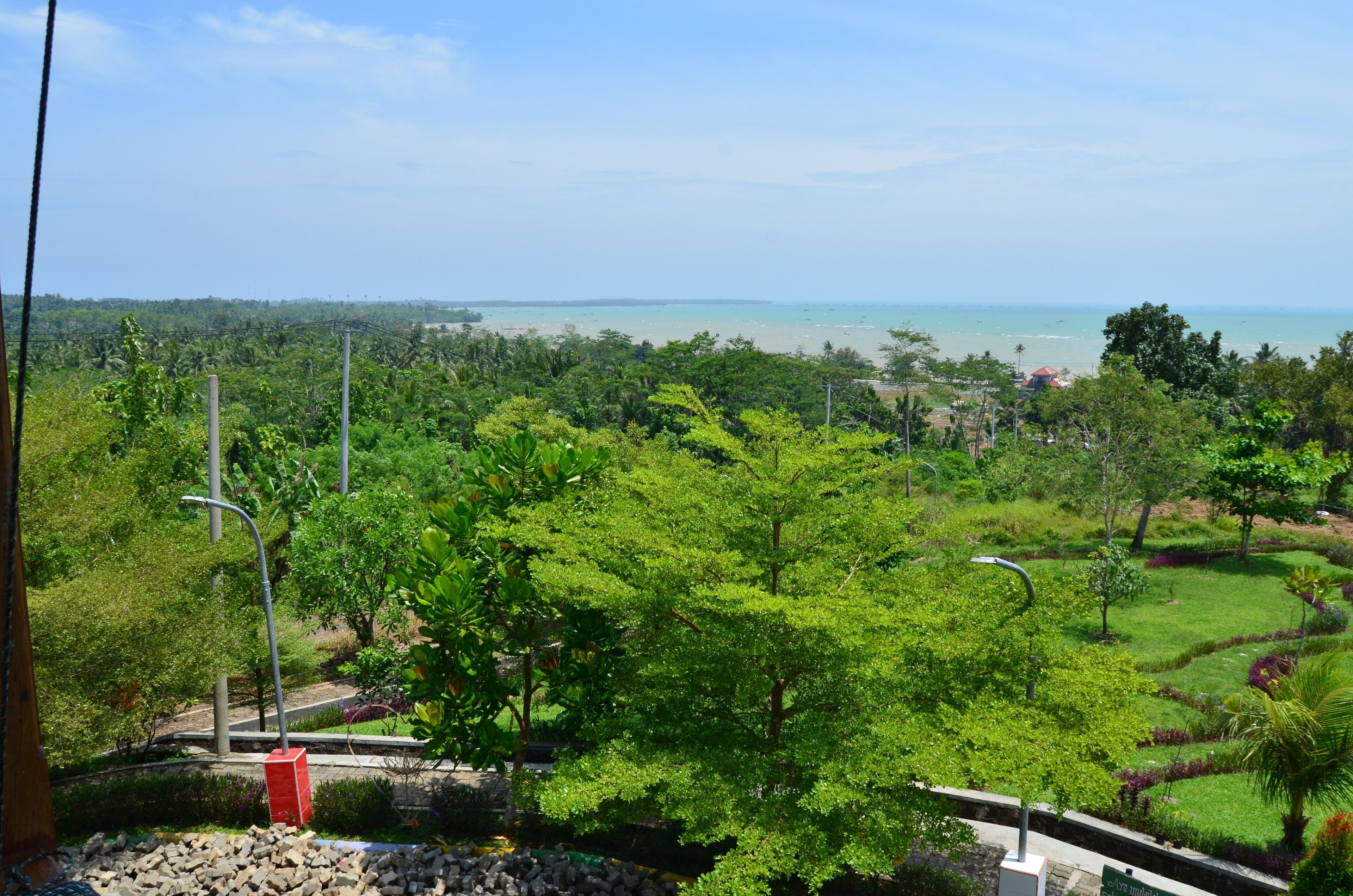 Paisagem verde exuberante com vista para a praia e oceano.