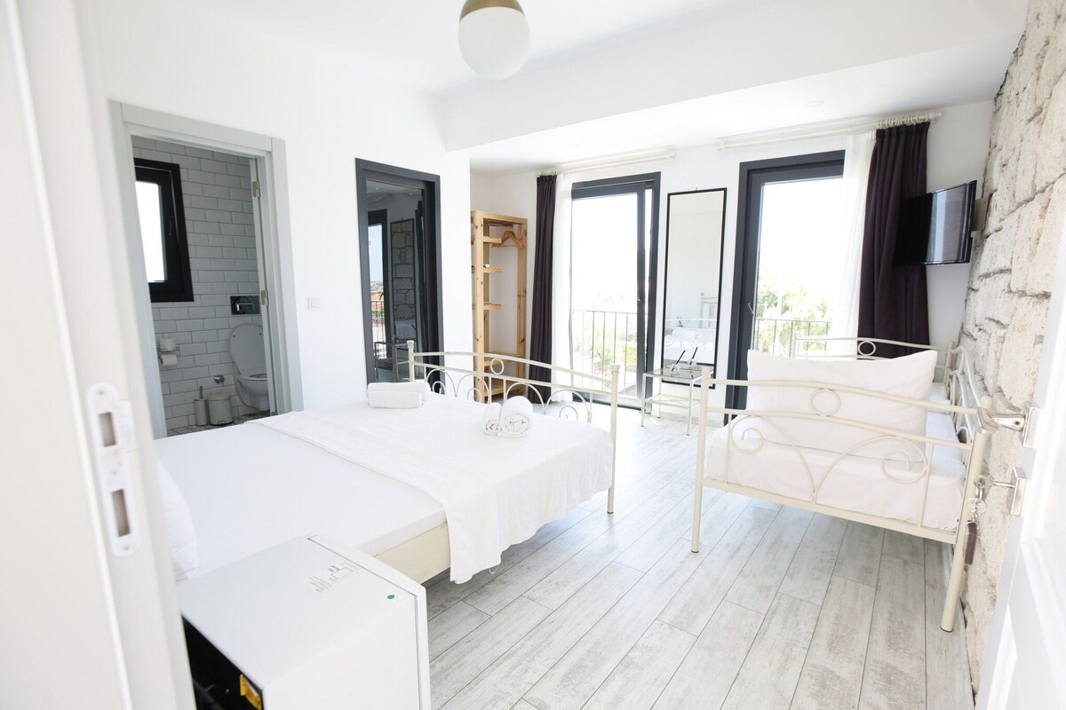 Quarto com cama, guarda-roupa, varanda e televisão.
