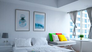 Quarto moderno com cama, mesa de cabeceira e janela com cortinas.