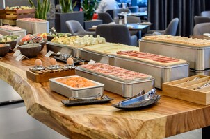 Um buffet com diversos alimentos e utensílios.