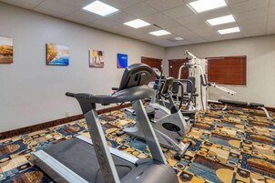 Uma academia com esteiras, elípticos e equipamentos de musculação.