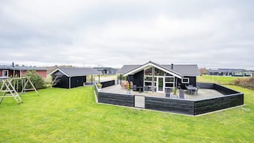 Um imóvel residencial com área de pátio, balanço e espaço de estar coberto ao ar livre.