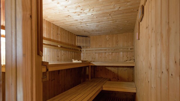 Uma sauna com bancos de madeira e piso de ripas.
