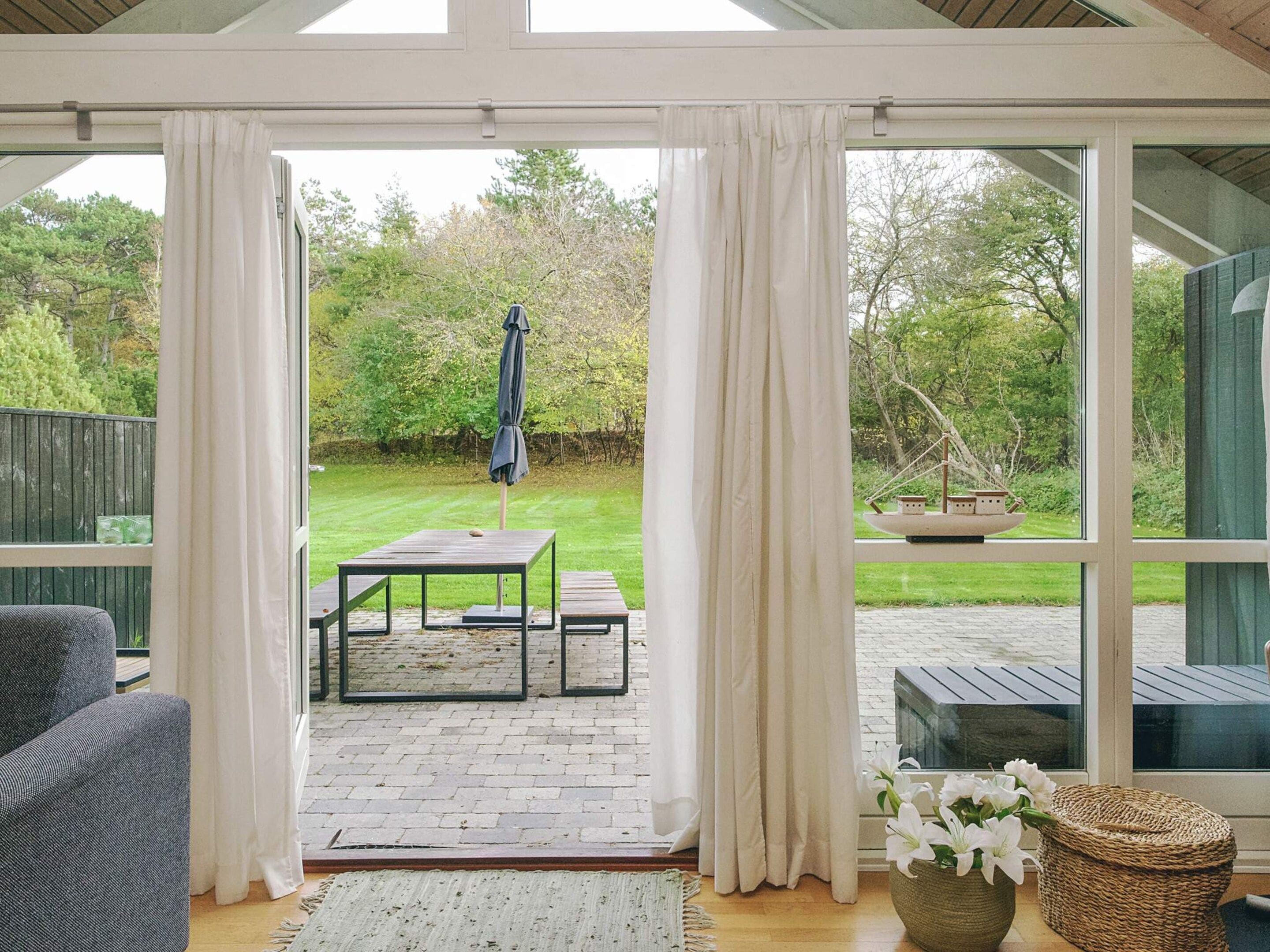 Quarto com vista para um jardim, uma mesa e um banco.