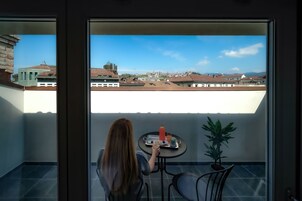 Uma varanda com mesa, cadeiras e um vaso de planta.