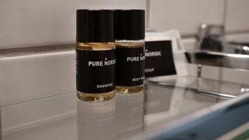 Dois frascos de Pure Nordic líquido de banho numa superfície espelhada.