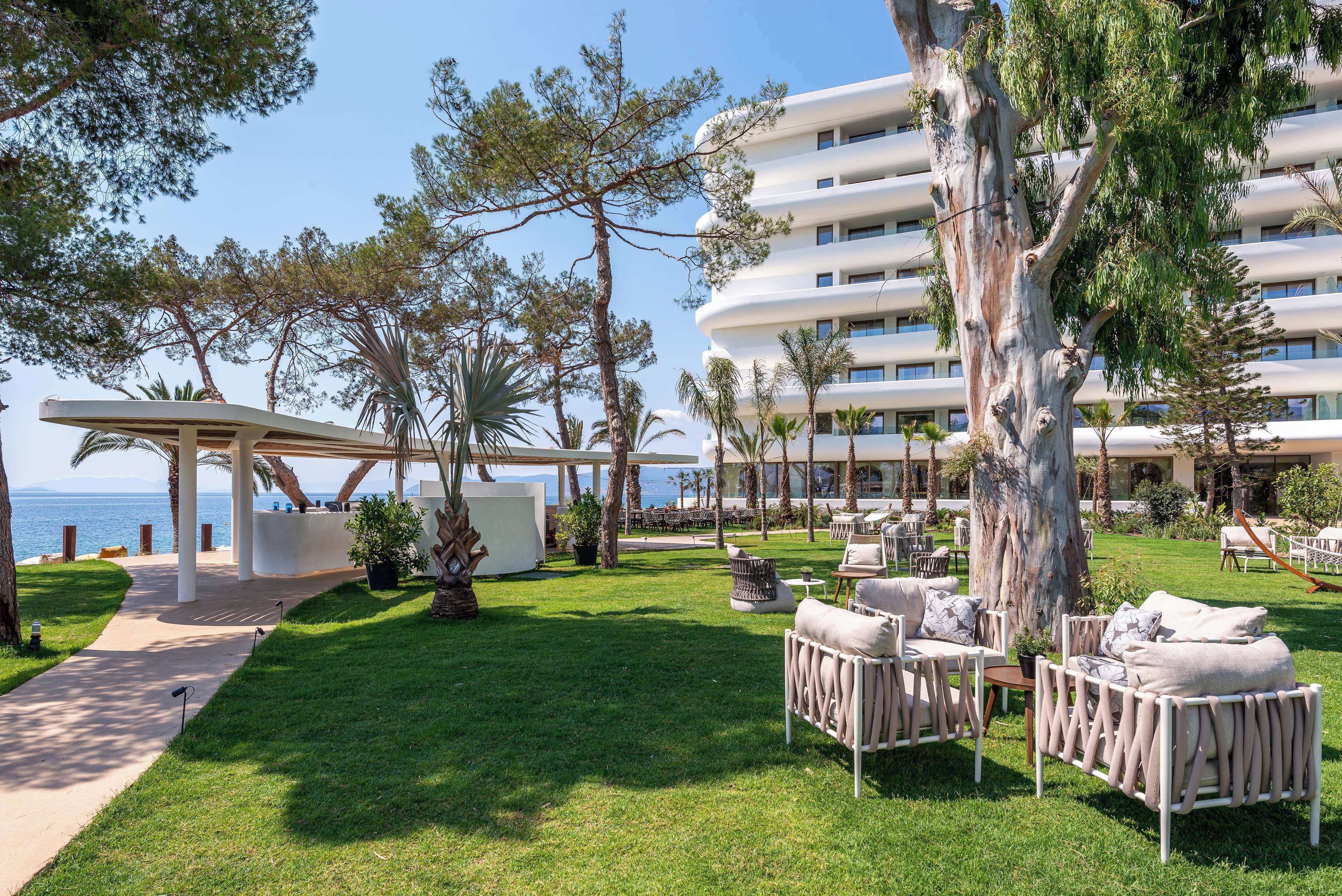 Um resort com área externa para sentar, espaço coberto e vista para o mar.