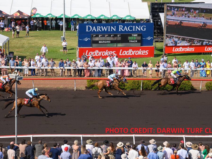 Corrida de cavalos em Darwin Racing, com espectadores nas arquibancadas.