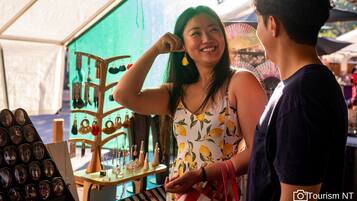 Uma banca de mercado com diversos artigos à venda, incluindo joias e bolsas.