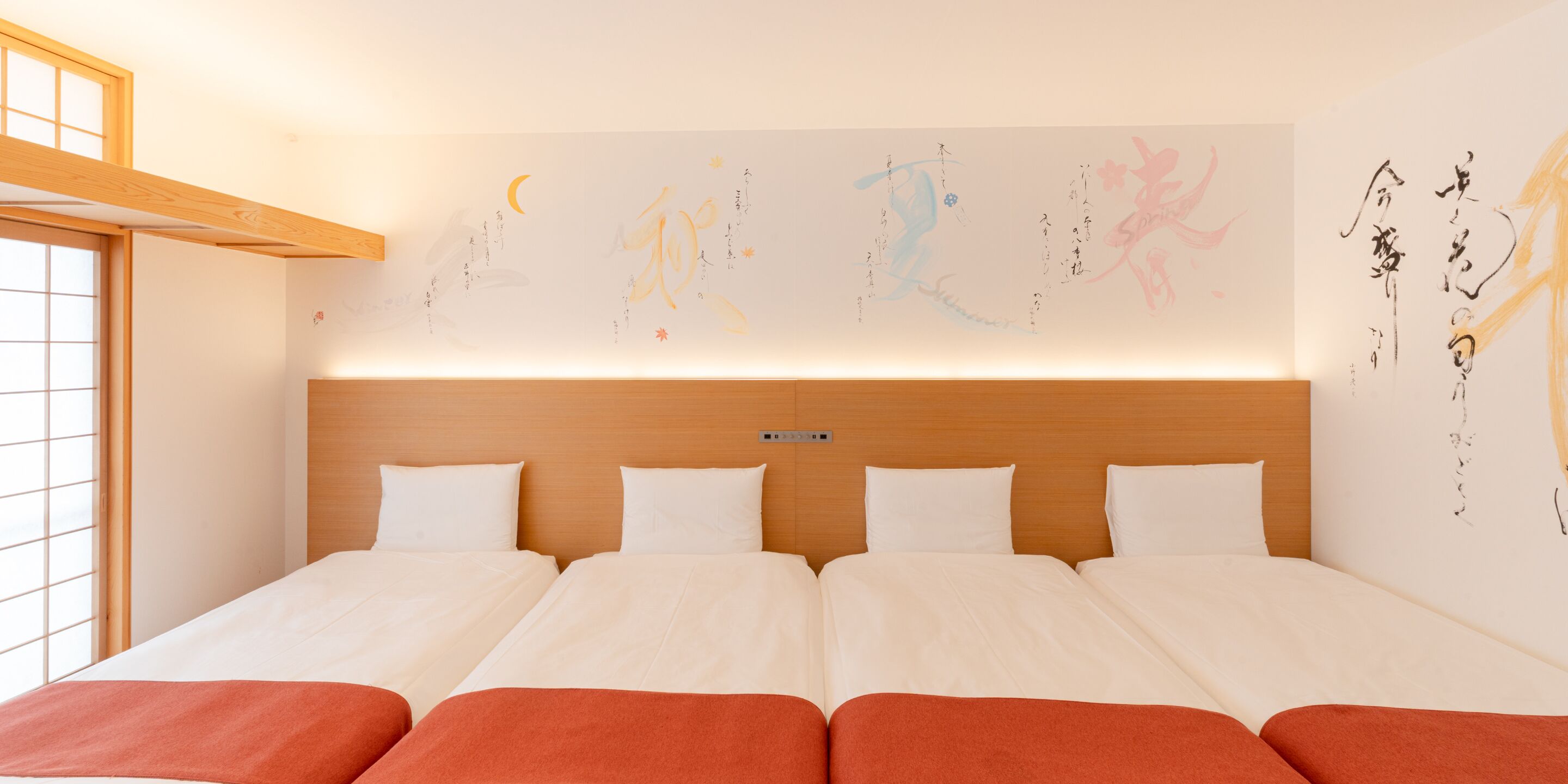 Quarto de hotel com uma cama grande, cabeceira de madeira e parede com obras de arte.