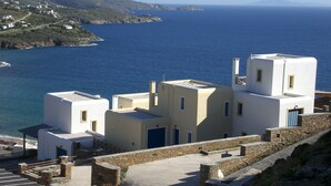 Um edifício costeiro com uma escadaria de pedra que leva a um terraço com vista para o mar.